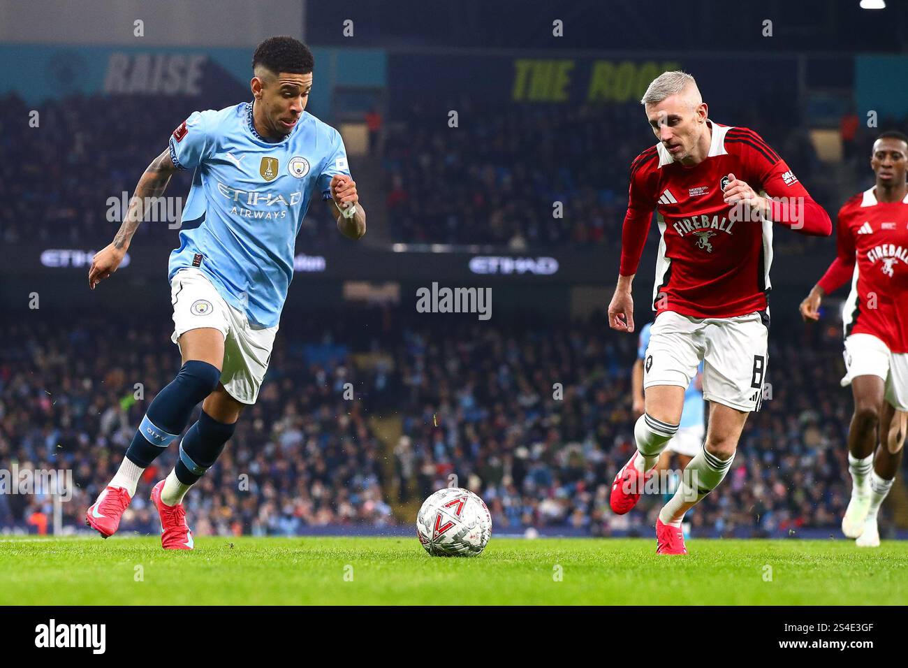 Savinho of Manchester City and Matty Lund of Salford City chase down ...
