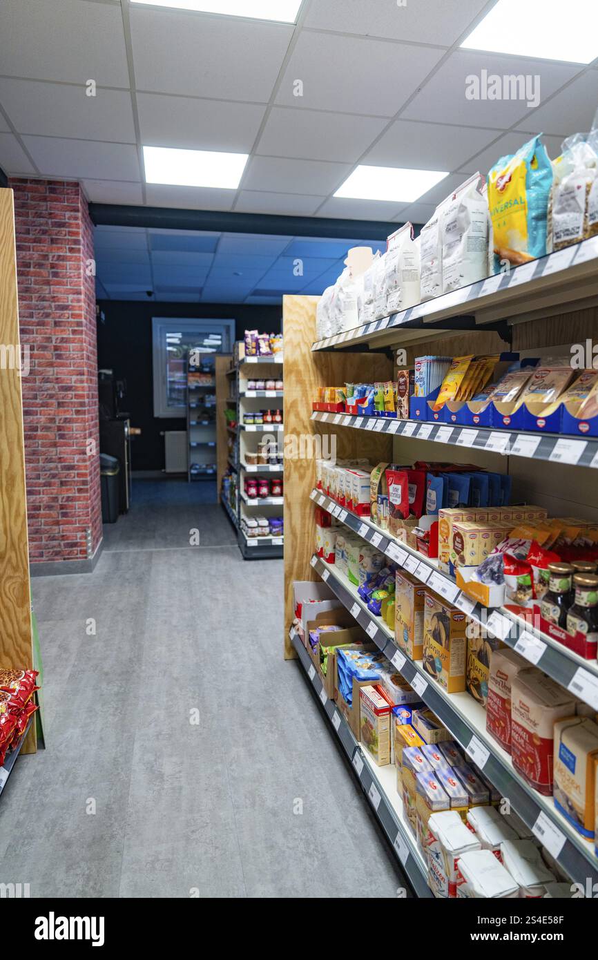 Modern supermarket with well-stocked shelves and light-coloured wooden ...
