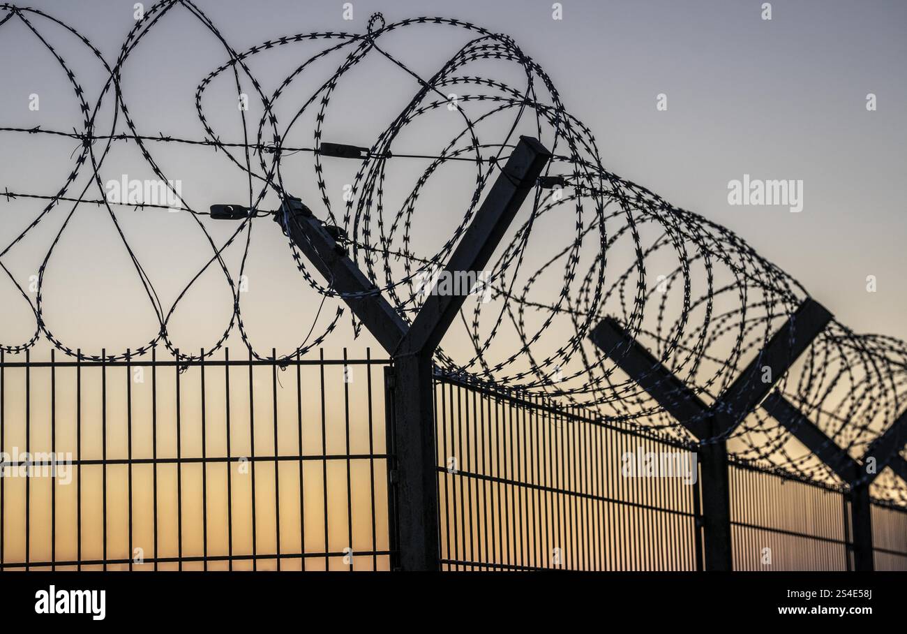 Symbolic image security, S-wire rolls, NATO wire, on a fence top ...