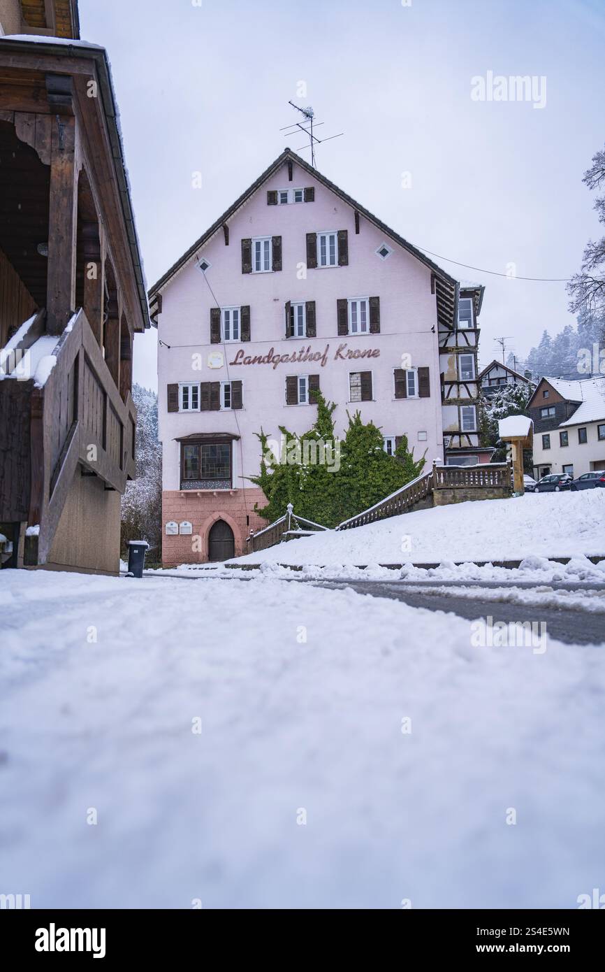Inn in winter with snow-covered pavement and traditional architecture ...