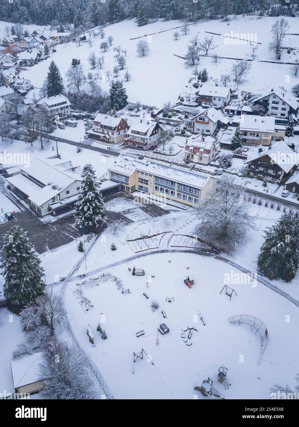 Snow-covered playground and school building in a small village ...