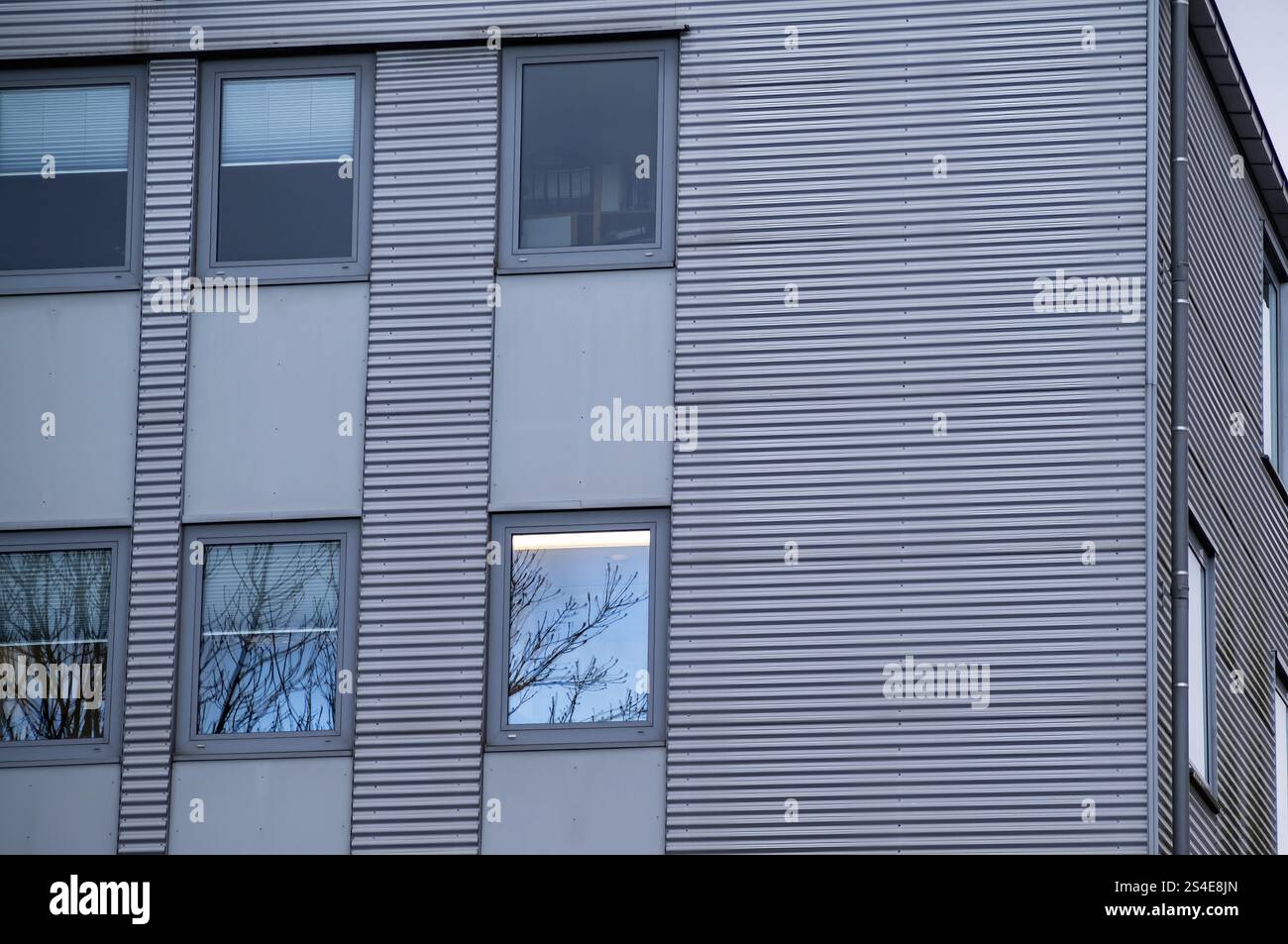 Modern building facade featuring windows and metal cladding, creating ...