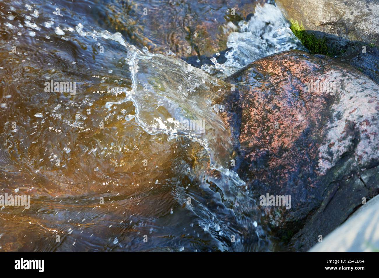 The captivating sight of flowing water gracefully cascading over rocks ...