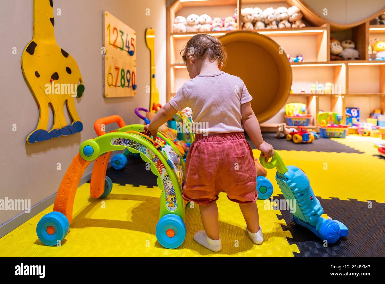 Child engaging with interactive toys and educational games in a bright ...