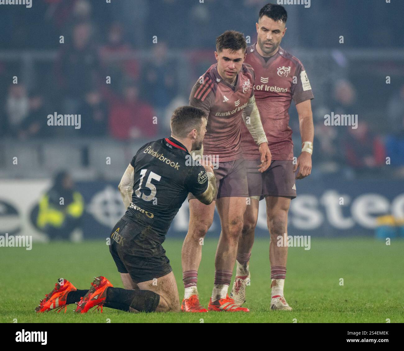 Jack Crowley of Munster helps Elliot Daly of Saracens up during the ...