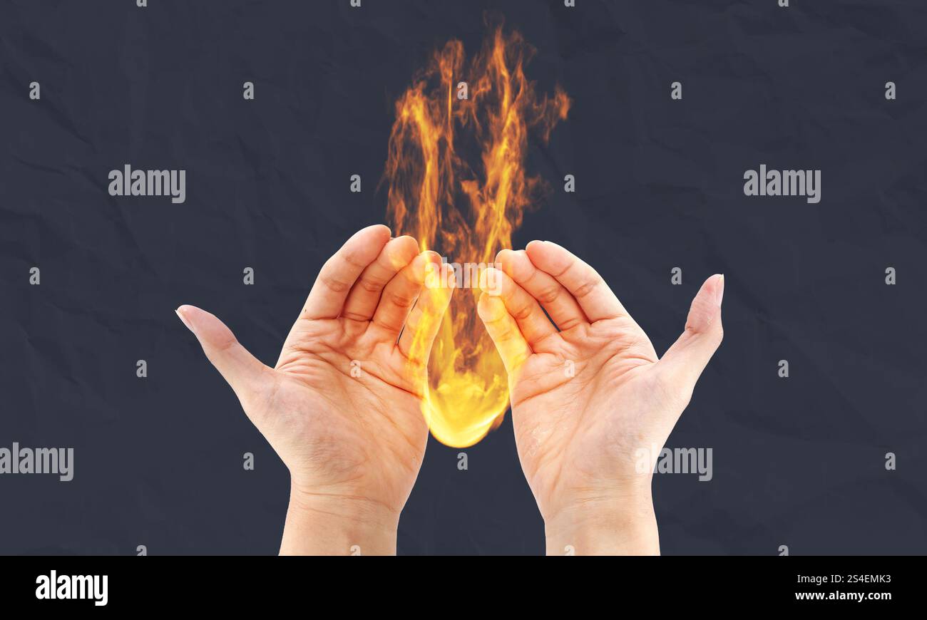 Hands holding fire isolated on dark background. Symbol of hope and ...