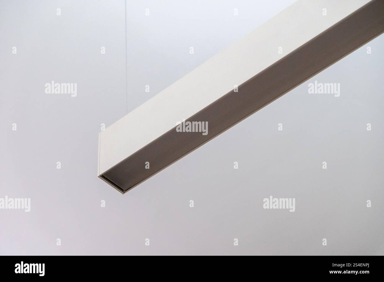 Suspended linear profile lighting featuring a prismatic cover, designed ...