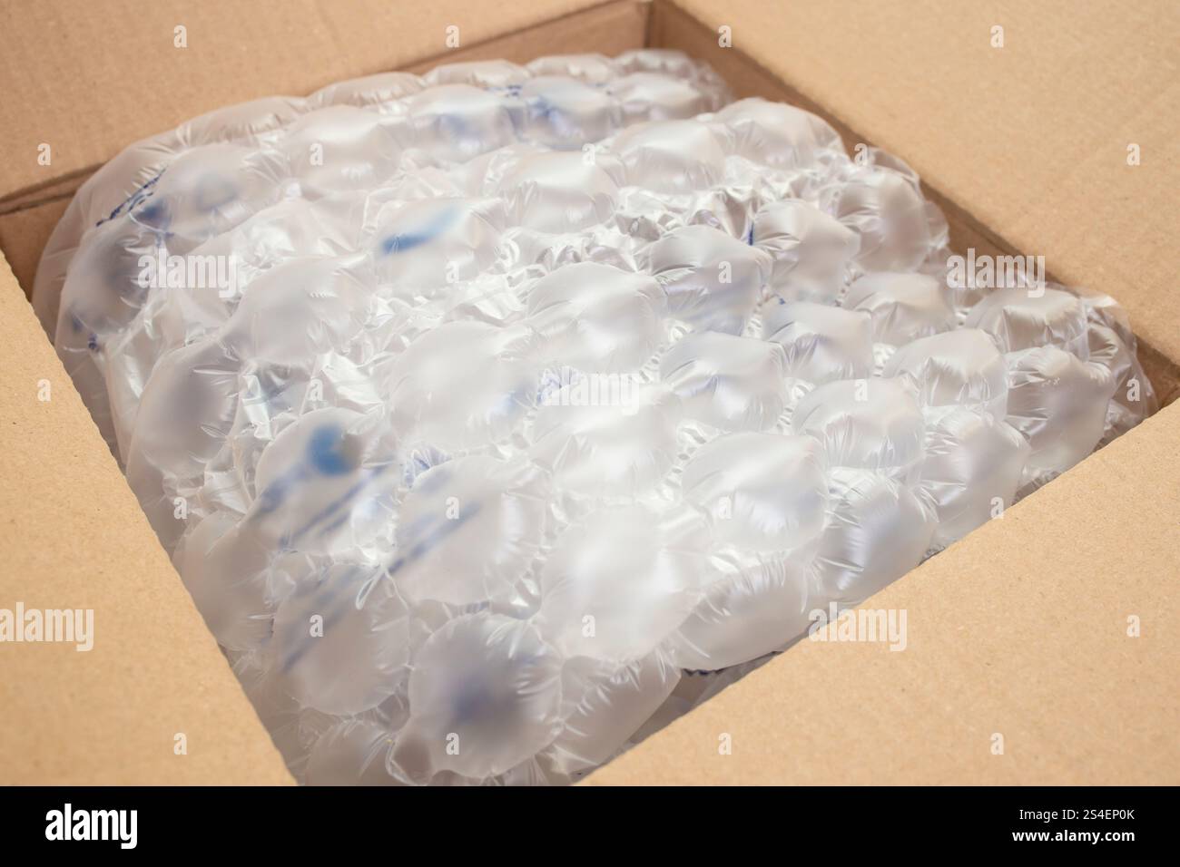 Cushion bubble wrap foil in a opened cardboard box, close up, abstract ...