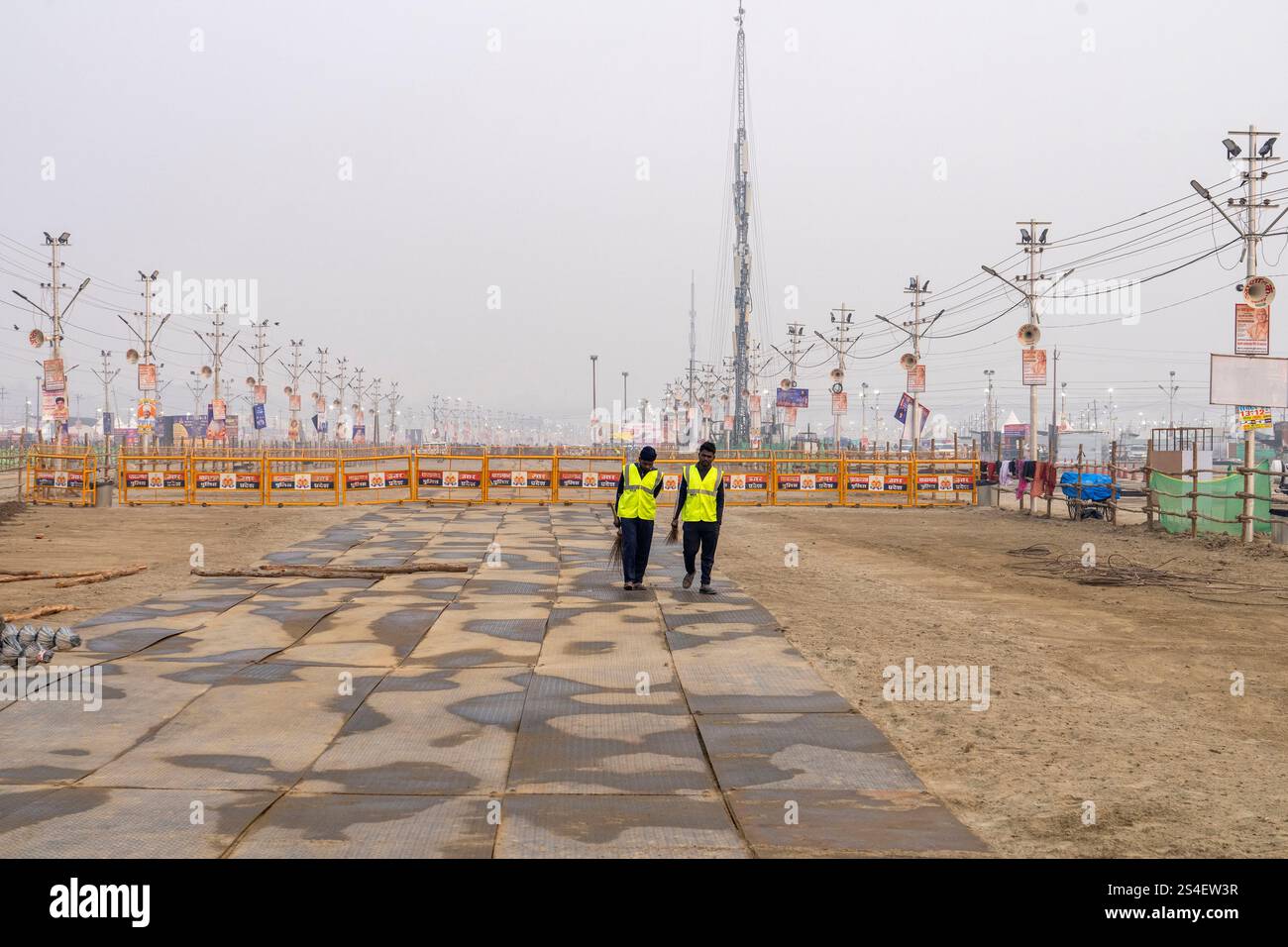 Sanitation workers walk after cleaning an area on the banks of the ...