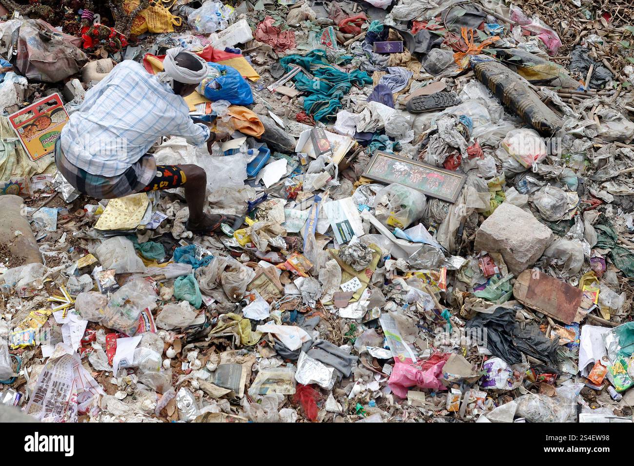 A waste picker collects recyclable materials in Madurai, Tamil Nadu ...