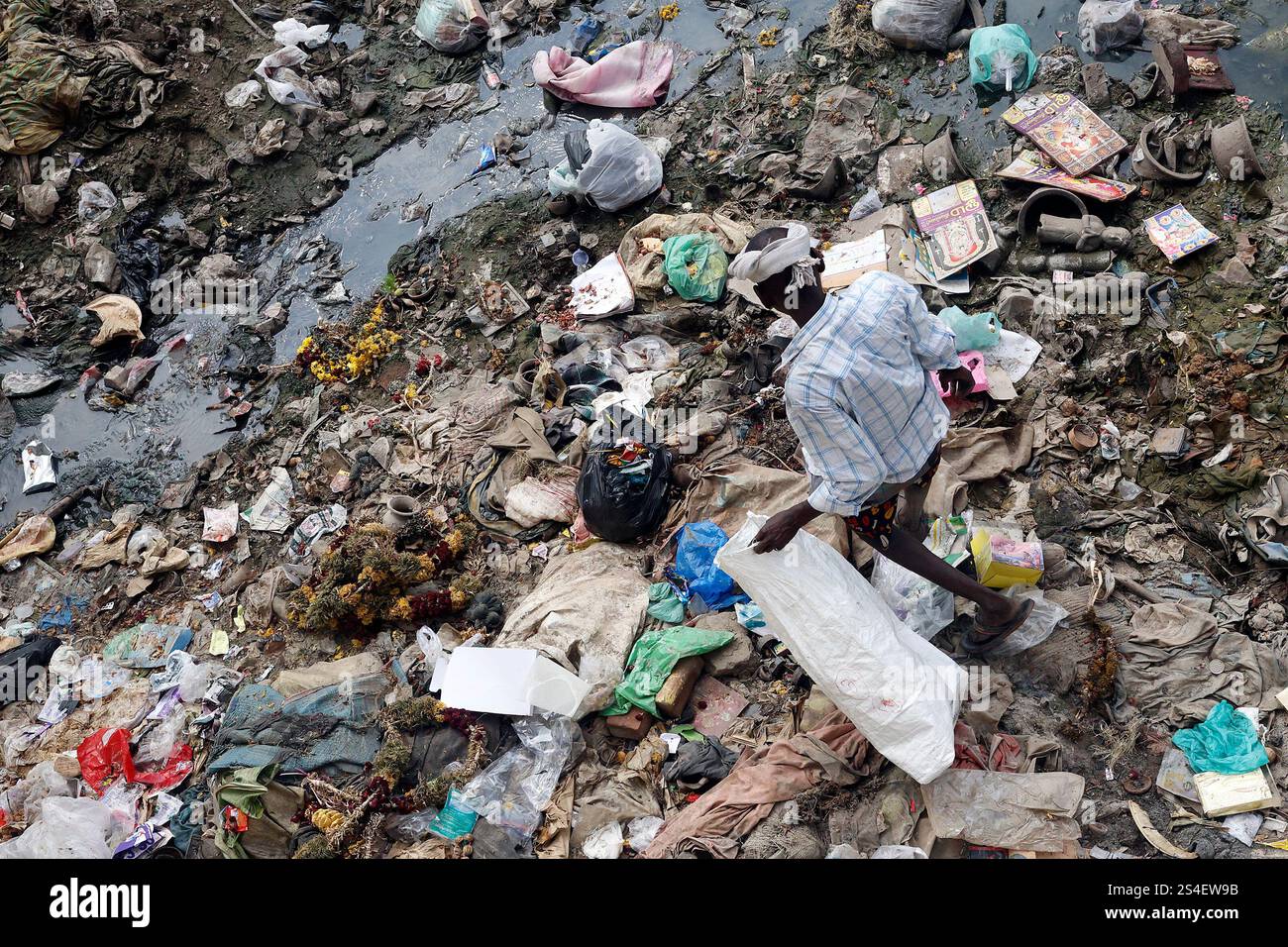 A waste picker collects recyclable materials in Madurai, Tamil Nadu ...