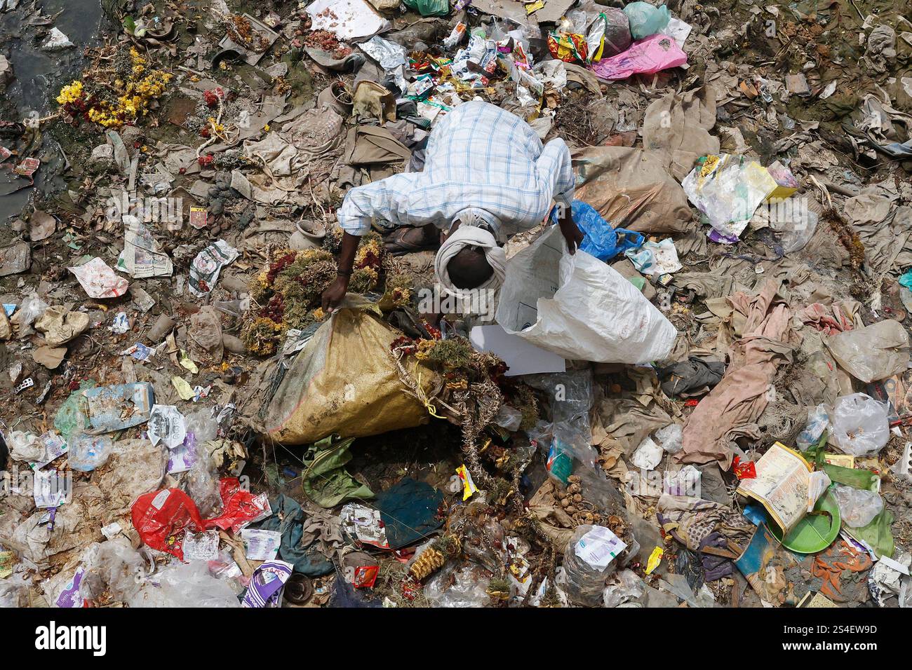 A waste picker collects recyclable materials in Madurai, Tamil Nadu ...