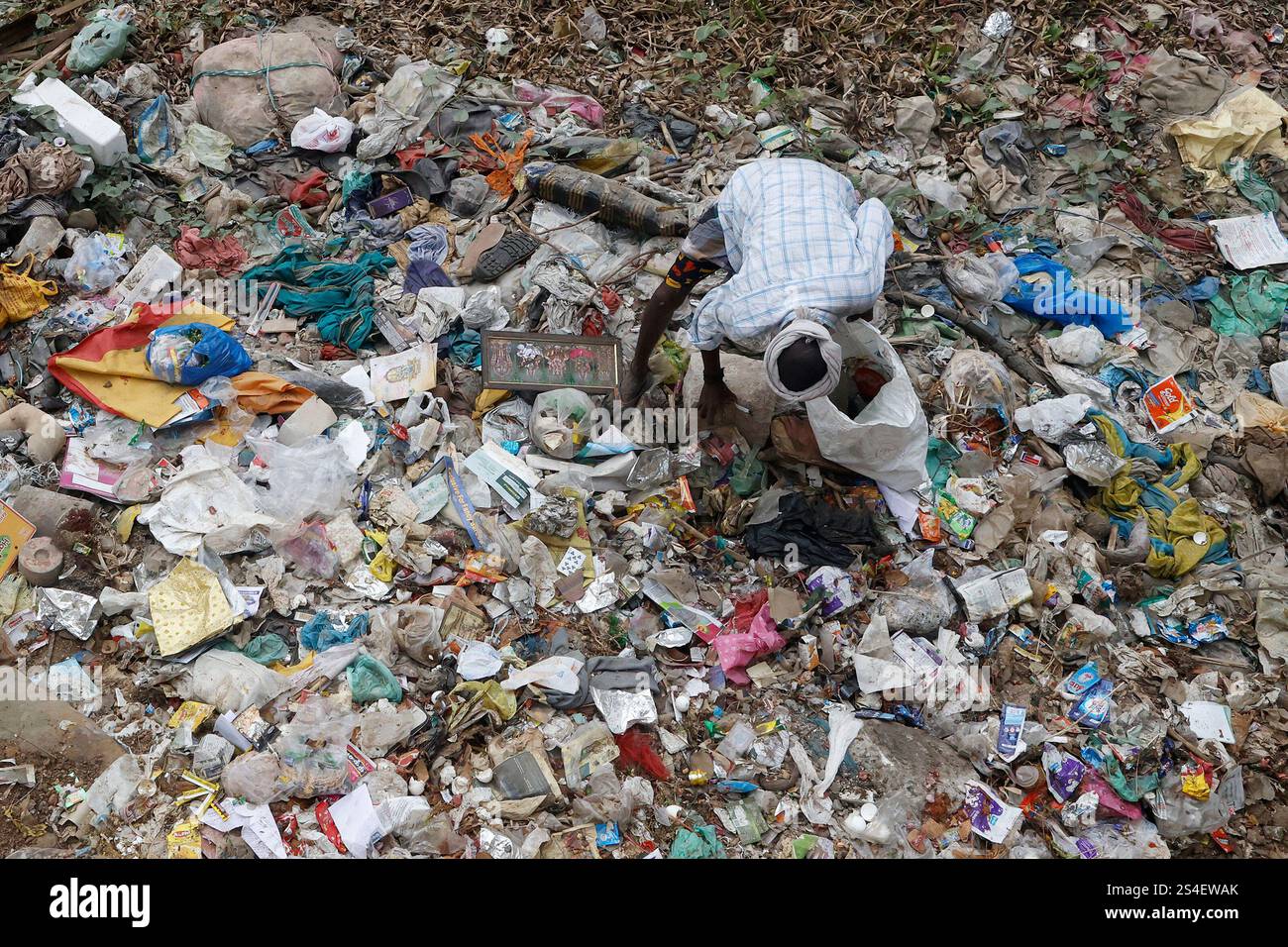 A waste picker collects recyclable materials in Madurai, Tamil Nadu ...
