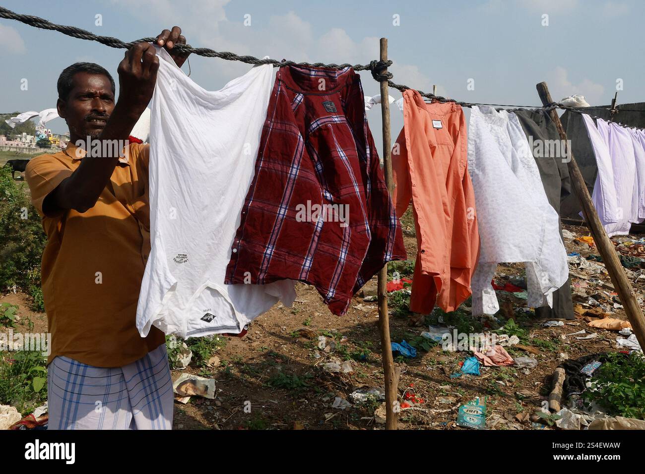 A dhobi wallah hangs out laundry to dry in the sun, in Madurai, Tamil ...