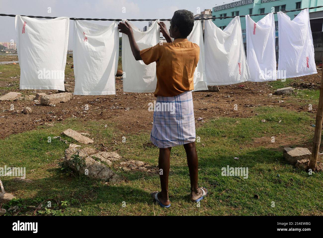 A dhobi wallah hangs out laundry to dry in the sun, in Madurai, Tamil ...