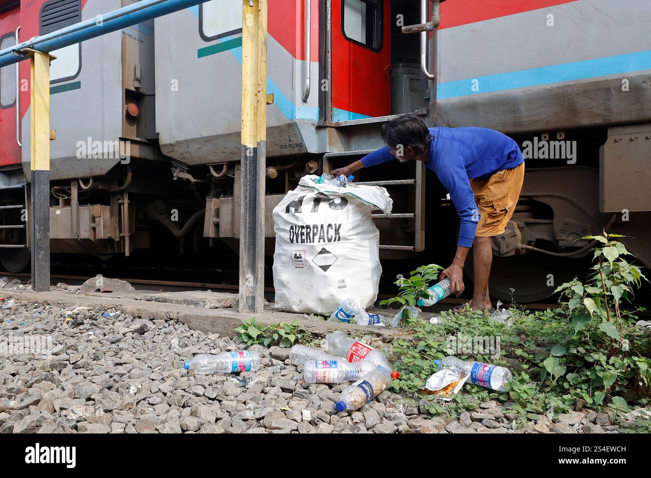 A waste picker collects plastic bottles for recycling in Madurai, Tamil ...