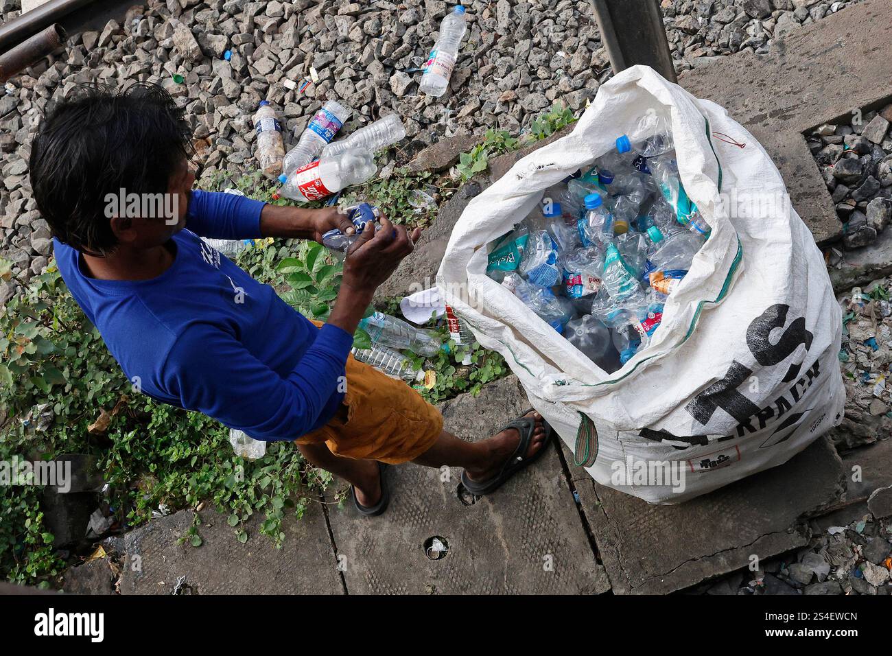 A waste picker collects plastic bottles for recycling in Madurai, Tamil ...