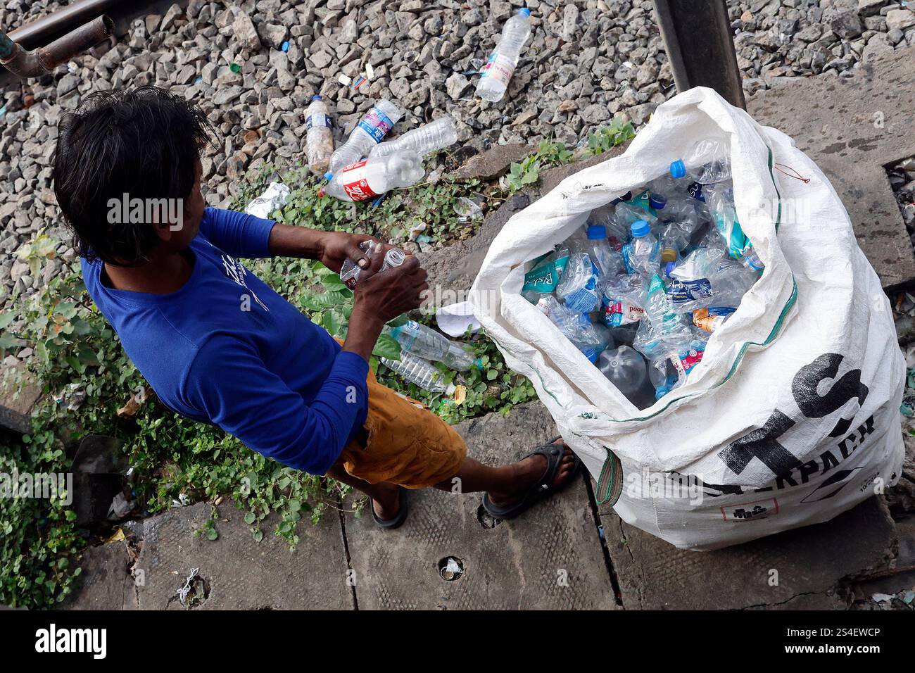 A waste picker collects plastic bottles for recycling in Madurai, Tamil ...