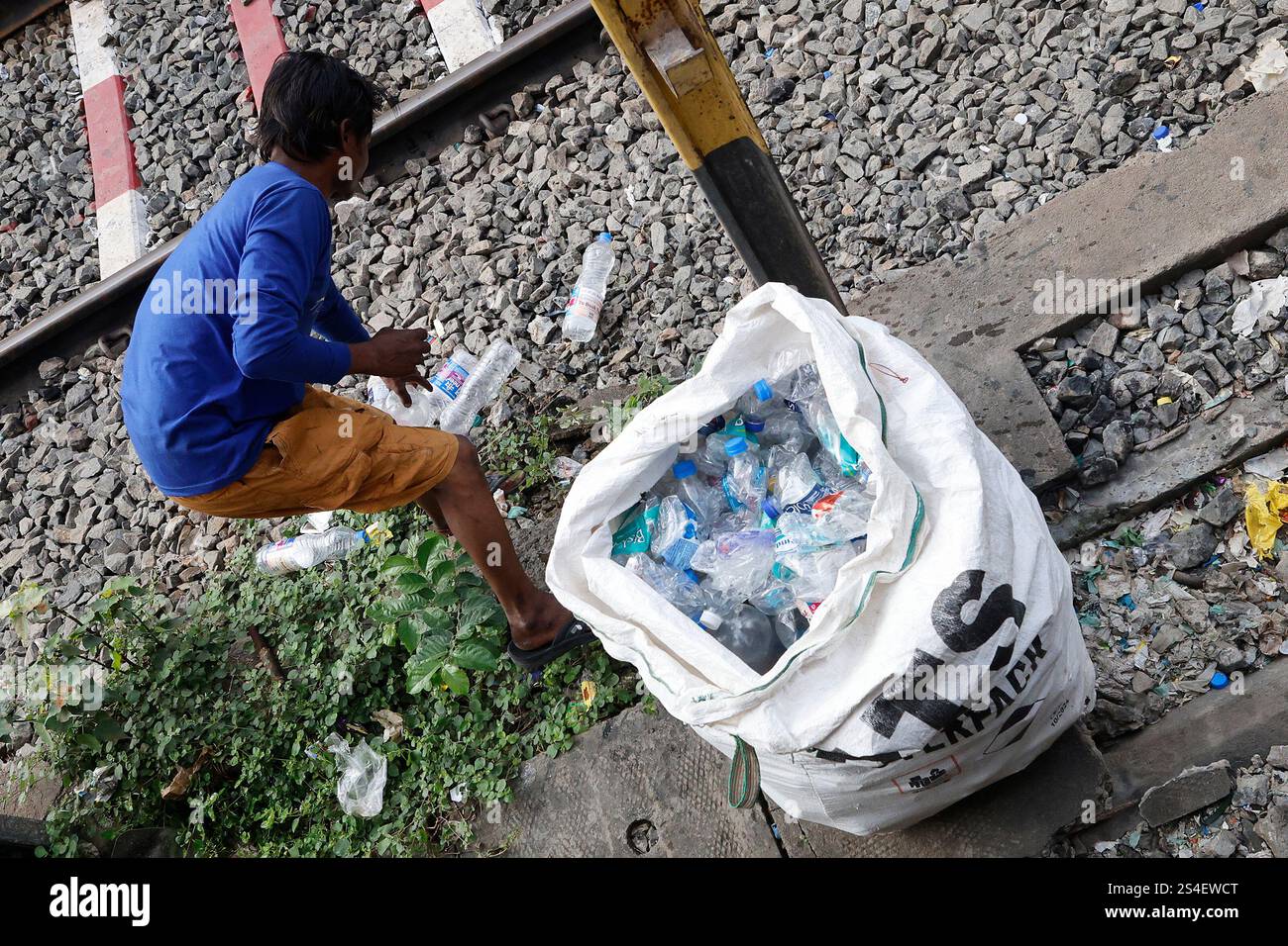 A waste picker collects plastic bottles for recycling in Madurai, Tamil ...