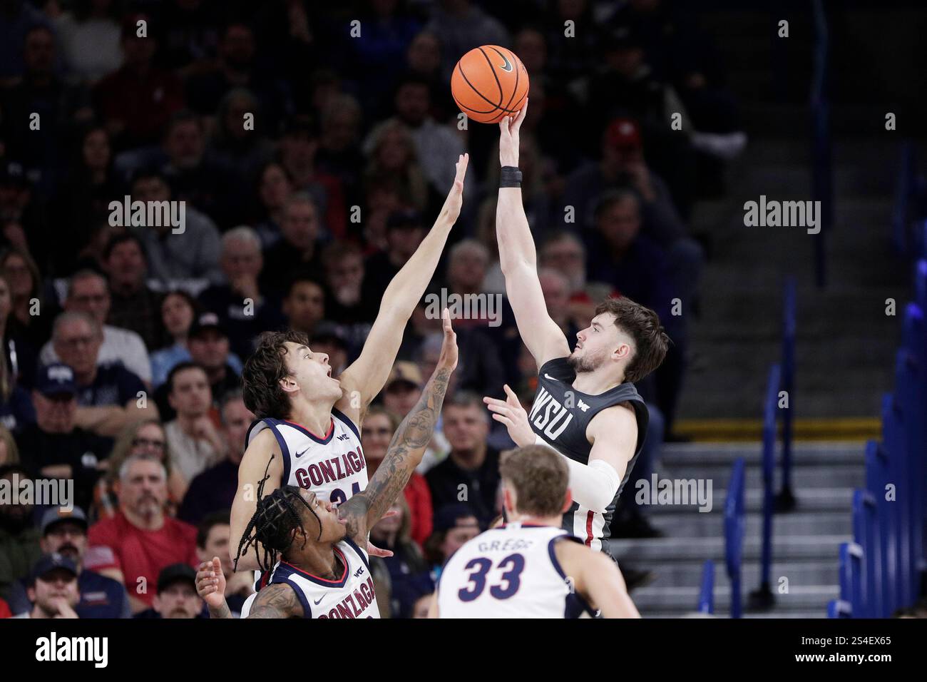 Washington State forward Ethan Price, right, shoots while pressured by ...