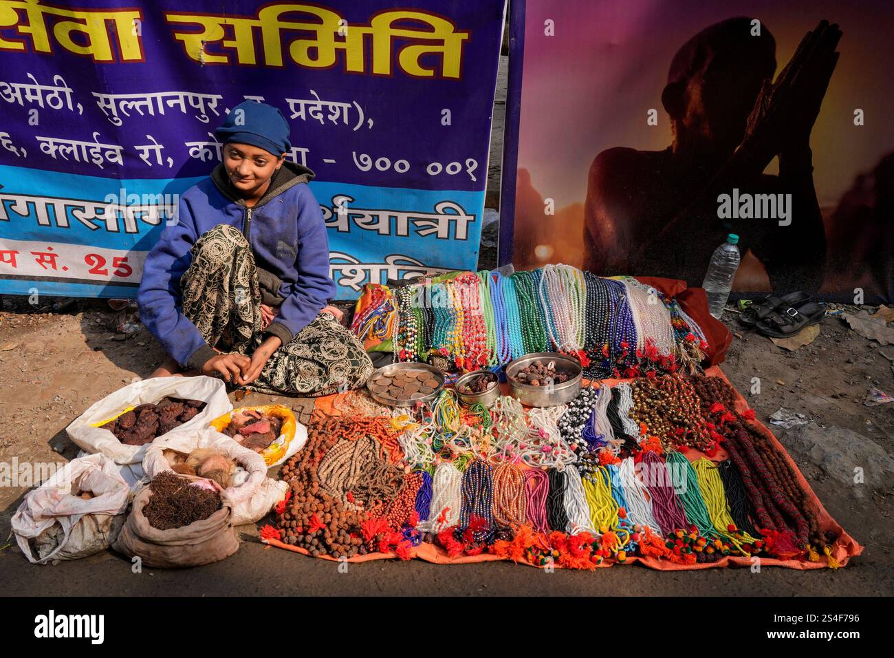 A nomad girl with various prayer beads on display waits for Hindu ...