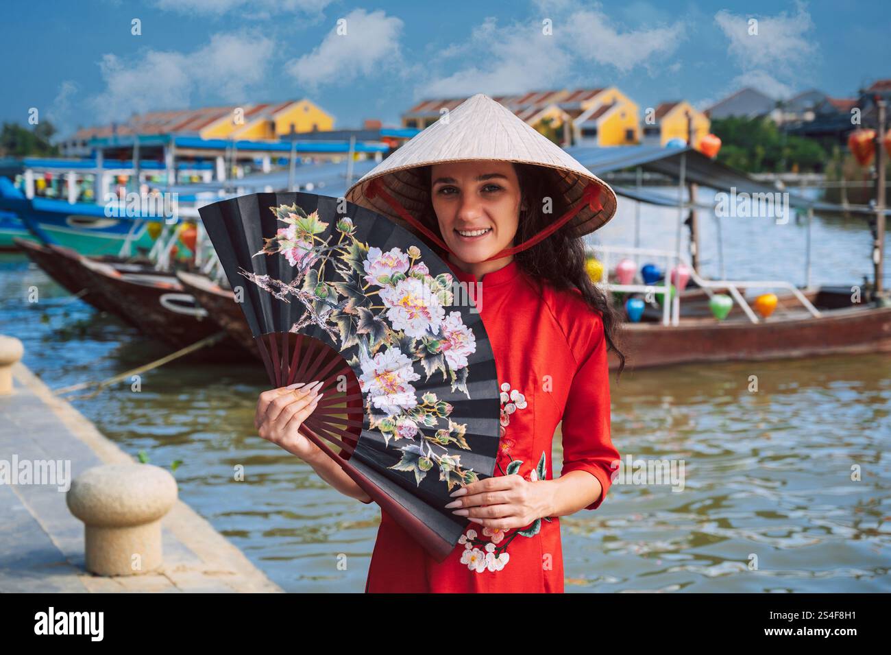 A woman in traditional Vietnamese culture clothes and a Non La hat in the ancient city of Hoi An ...