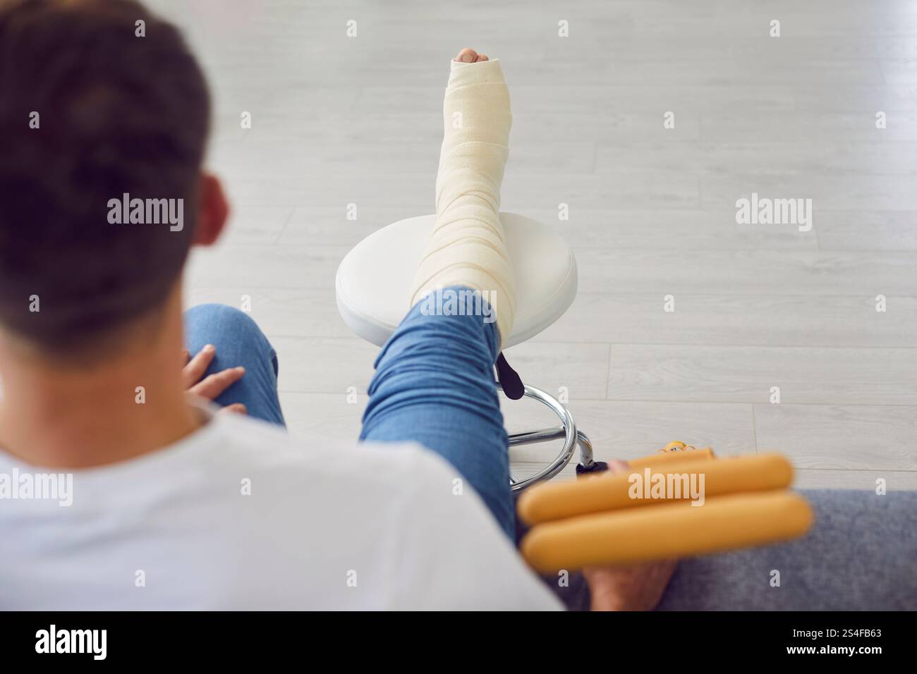 Man sitting for rehabilitation after serious leg, foot trauma, physical ...