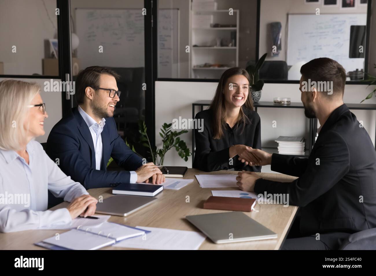 Two business partners shaking hands in conference room Stock Photo - Alamy