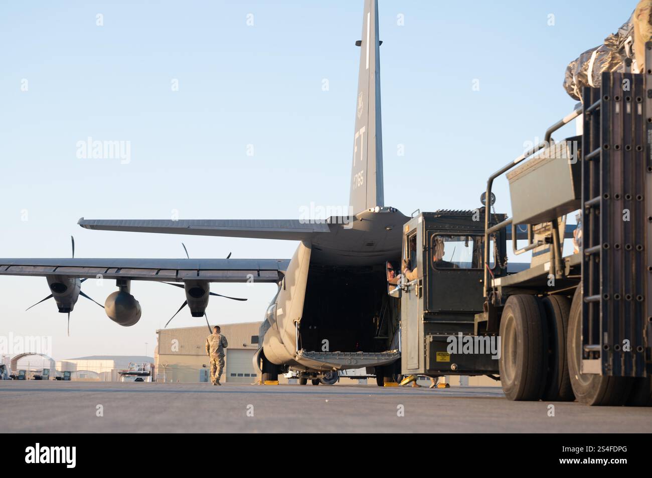 A U.S. Air Force K-24 Loader prepares to pull up to an HC-130J Combat ...