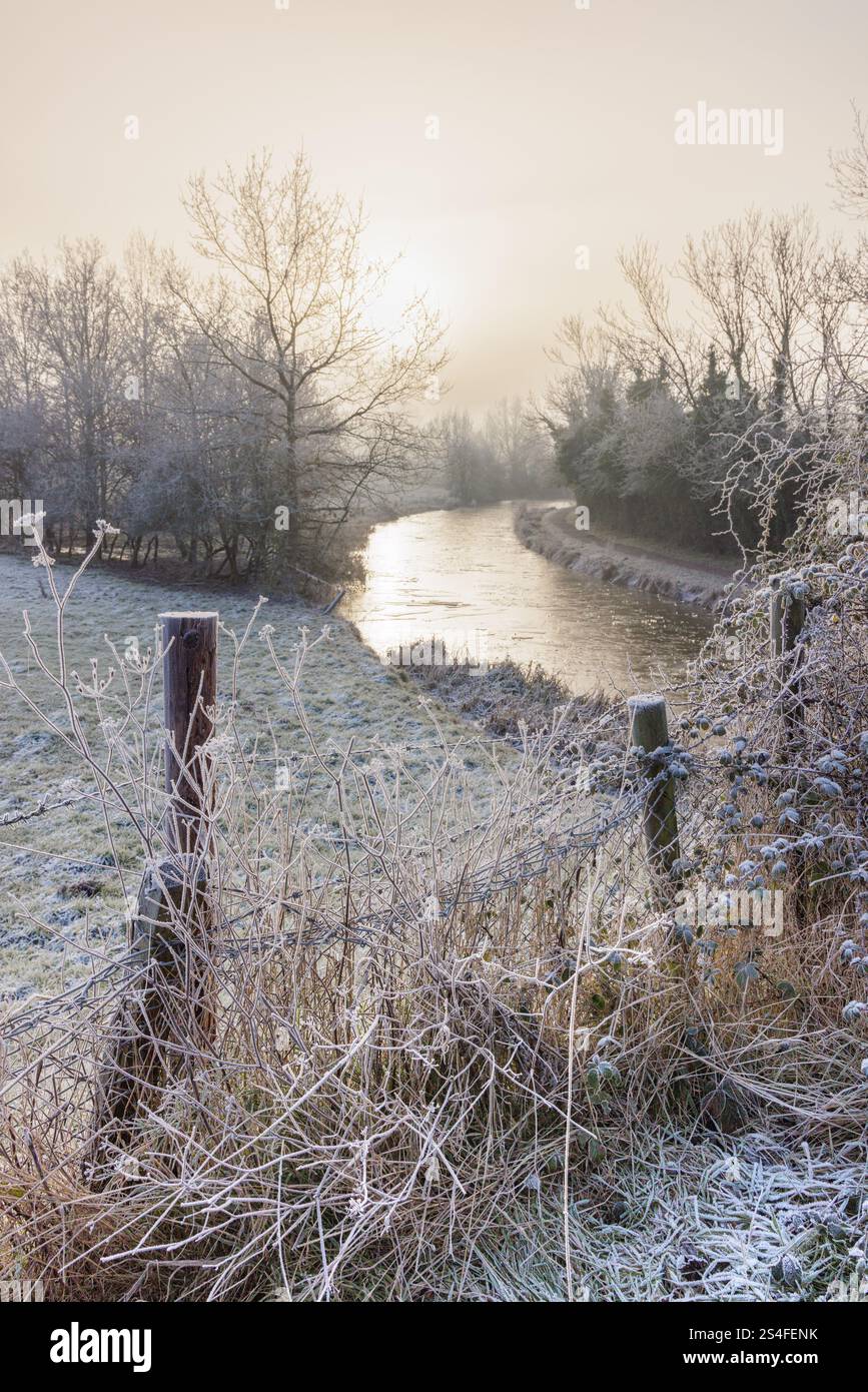Northamptonshire, UK, 2025: A mist-shrouded sun rises above a bend of ...