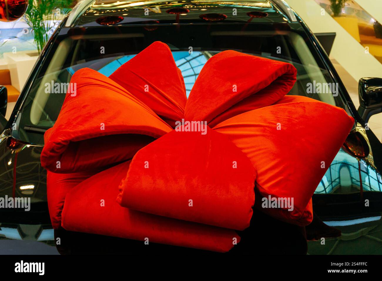 a big red bow on a new car. gift wrapping at a car dealership Stock ...