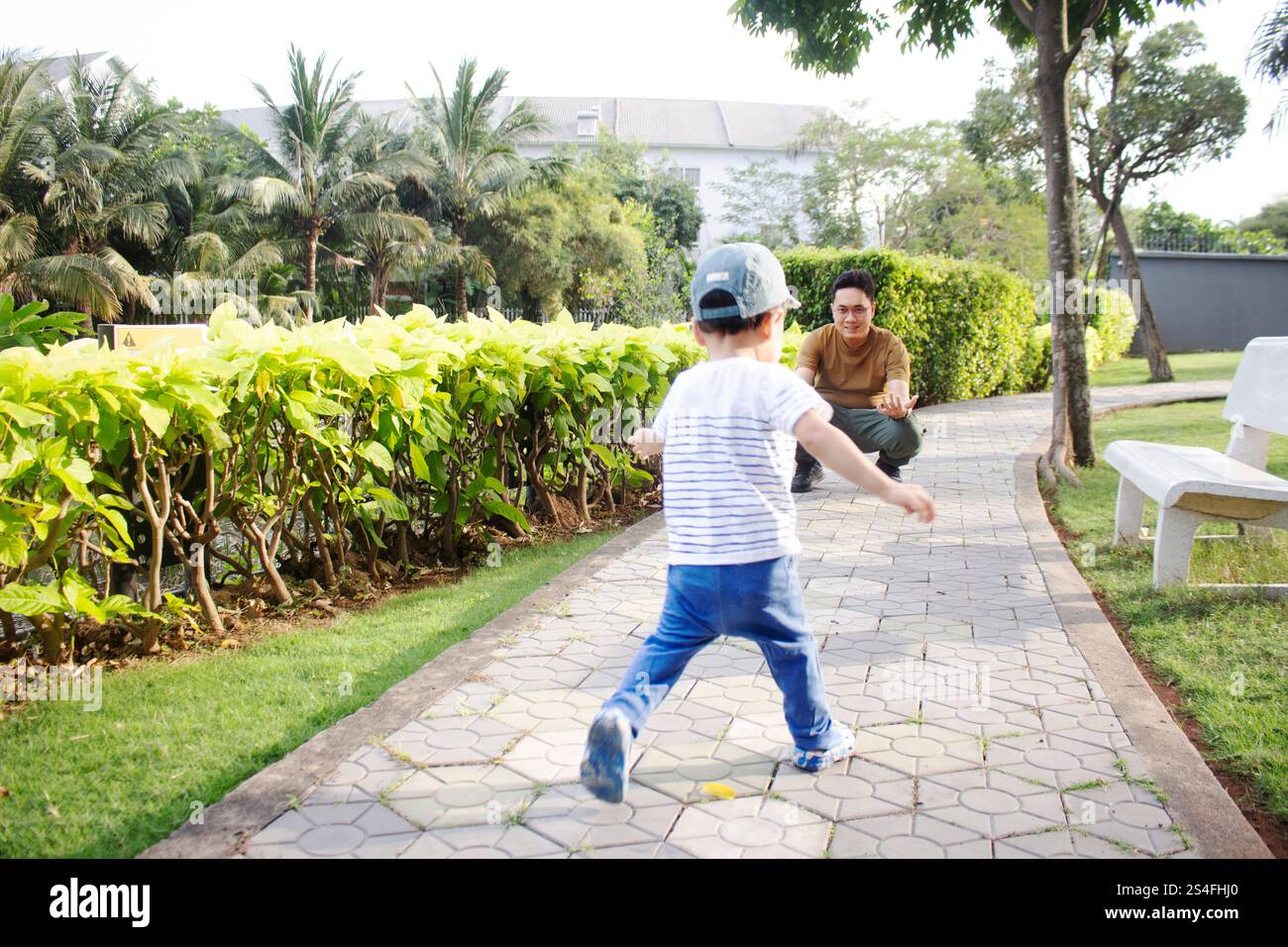 Father and son are playing together in the park, baby is running ...