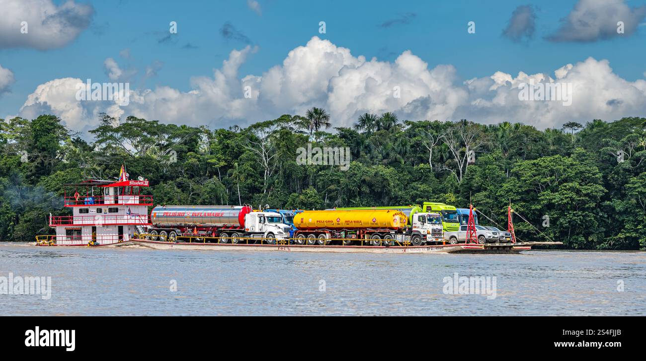 Transport tug boat on Napo River carrying large trucks and oil tankers ...
