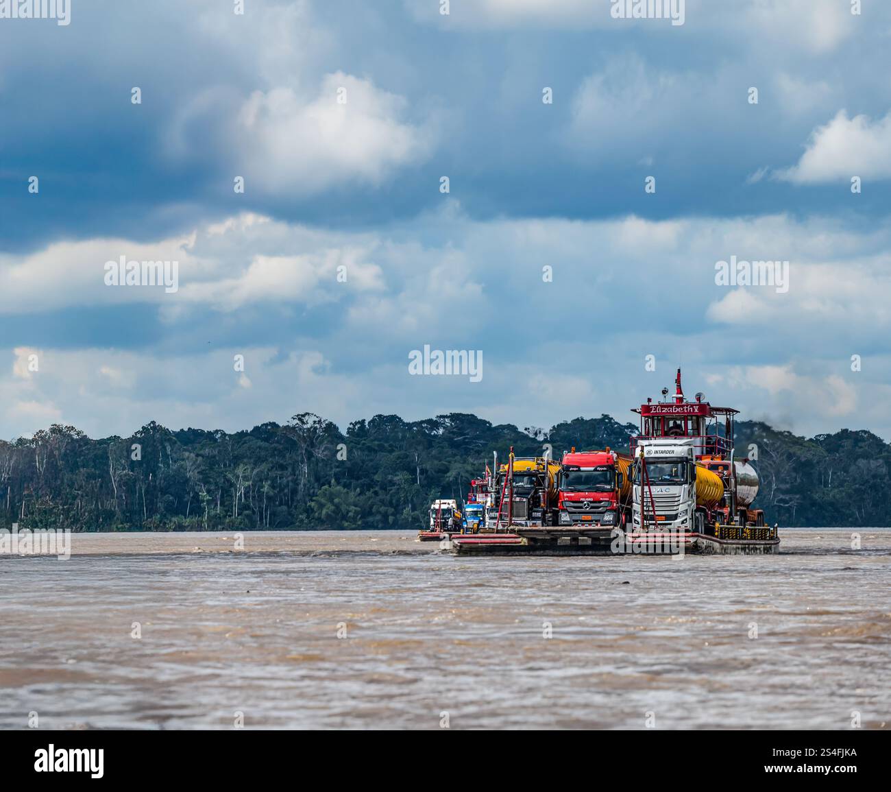 Transport tug boat on Napo River carrying large trucks and oil tankers ...