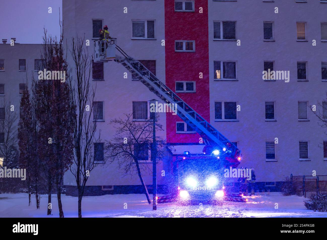 Winter rescue operation in an apartment building, fire truck with a ...