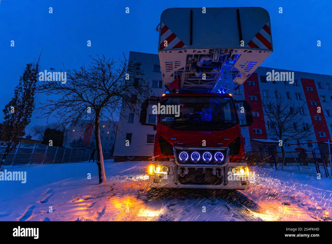 Red fire truck with a long ladder at the scene, difficult weather ...