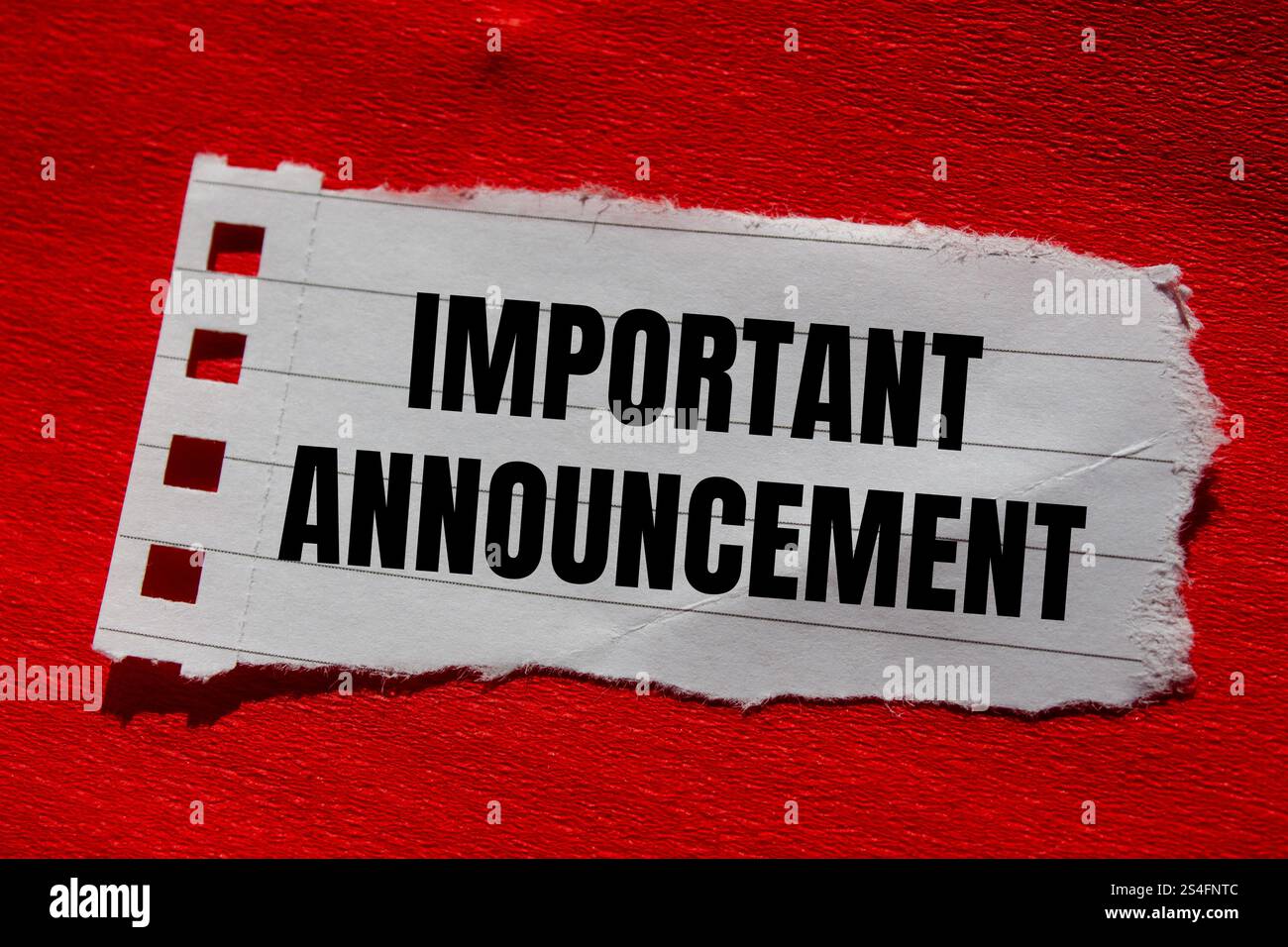 Important announcement message written on ripped torn paper piece with red background ...