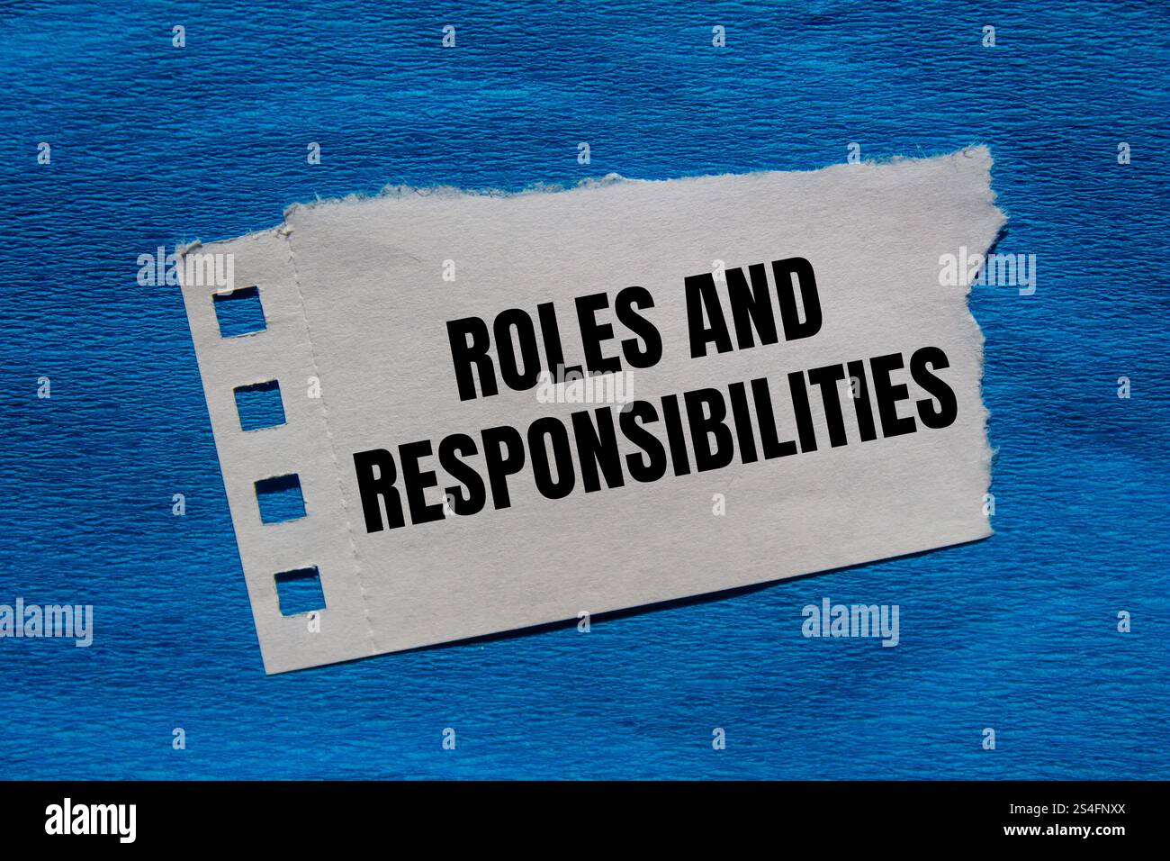 Roles and responsibilities message written on ripped torn paper piece ...