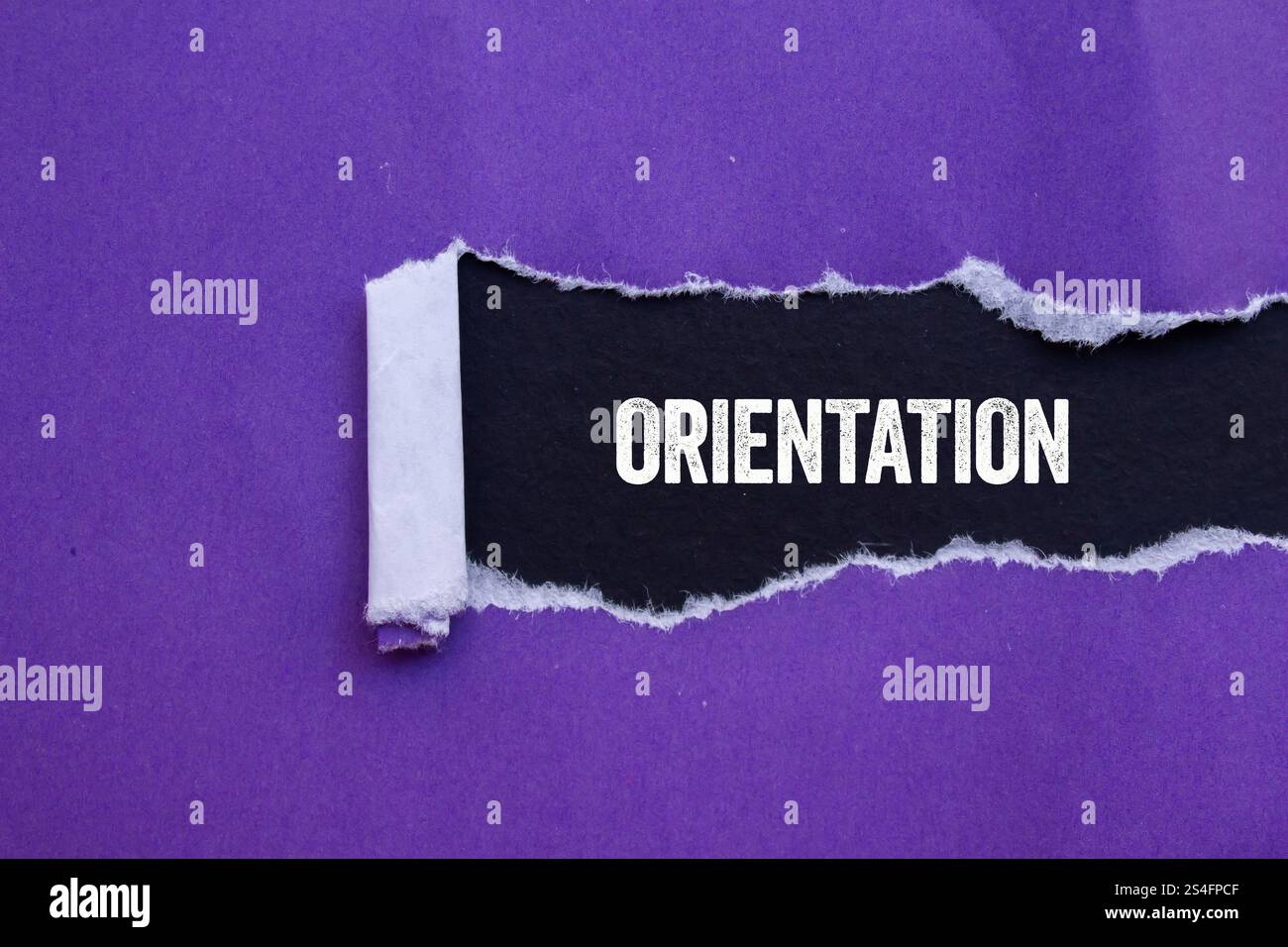 Orientation message written on ripped torn purple paper on black ...