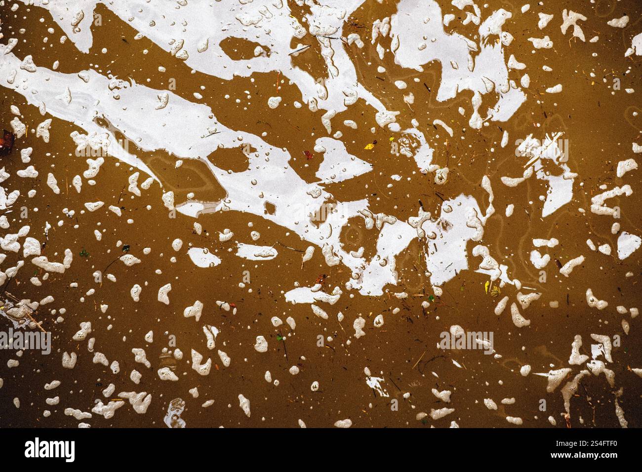 Abstract pattern of muddy water with foam and floating debris, evoking ...