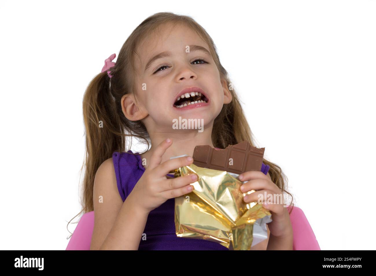 A four-year-old girl suffers from a toothache while eating chocolate ...
