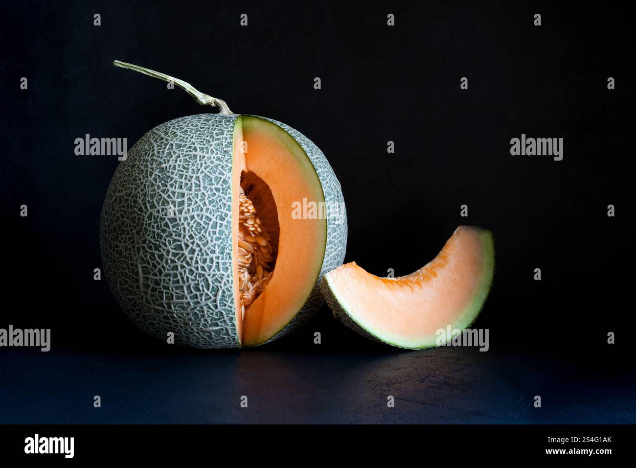 Whole and sliced Japanese melons, honey melon or cantaloupe on black ...