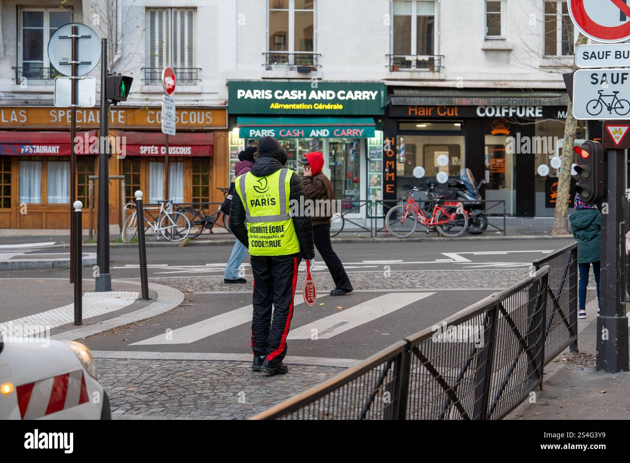 Pedestrian crossing in Paris with a safety officer directing activity ...