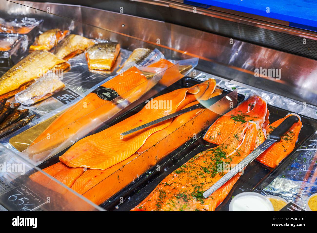 Fresh smoked and marinated salmon fillets displayed on ice in grocery ...