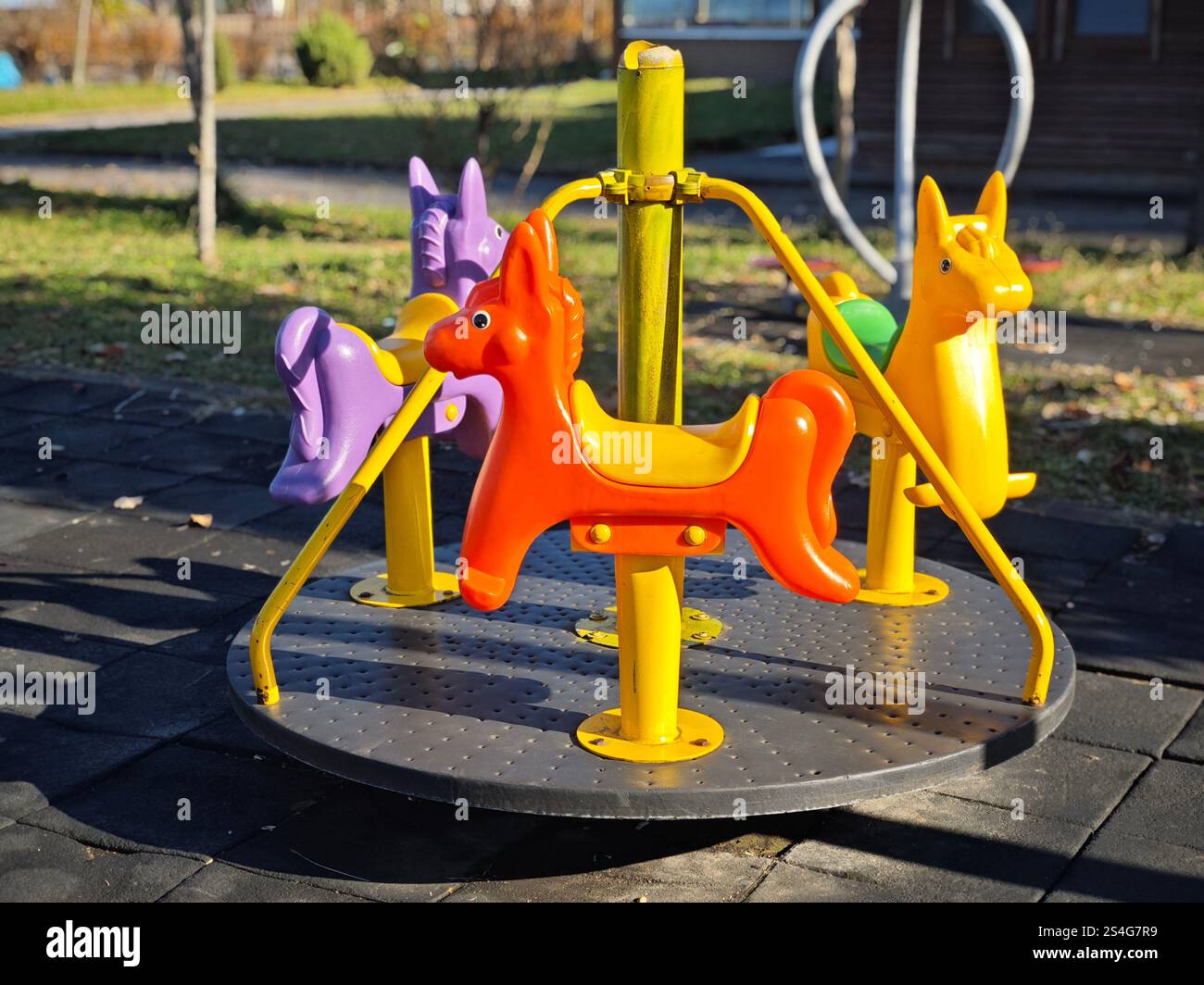 Colorful rocking horse carousels in an outdoor children's playground ...