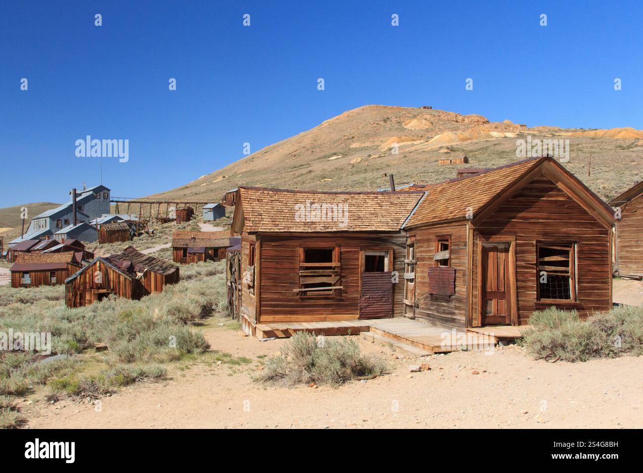 A small house sits in the middle of a desert. The house is surrounded ...