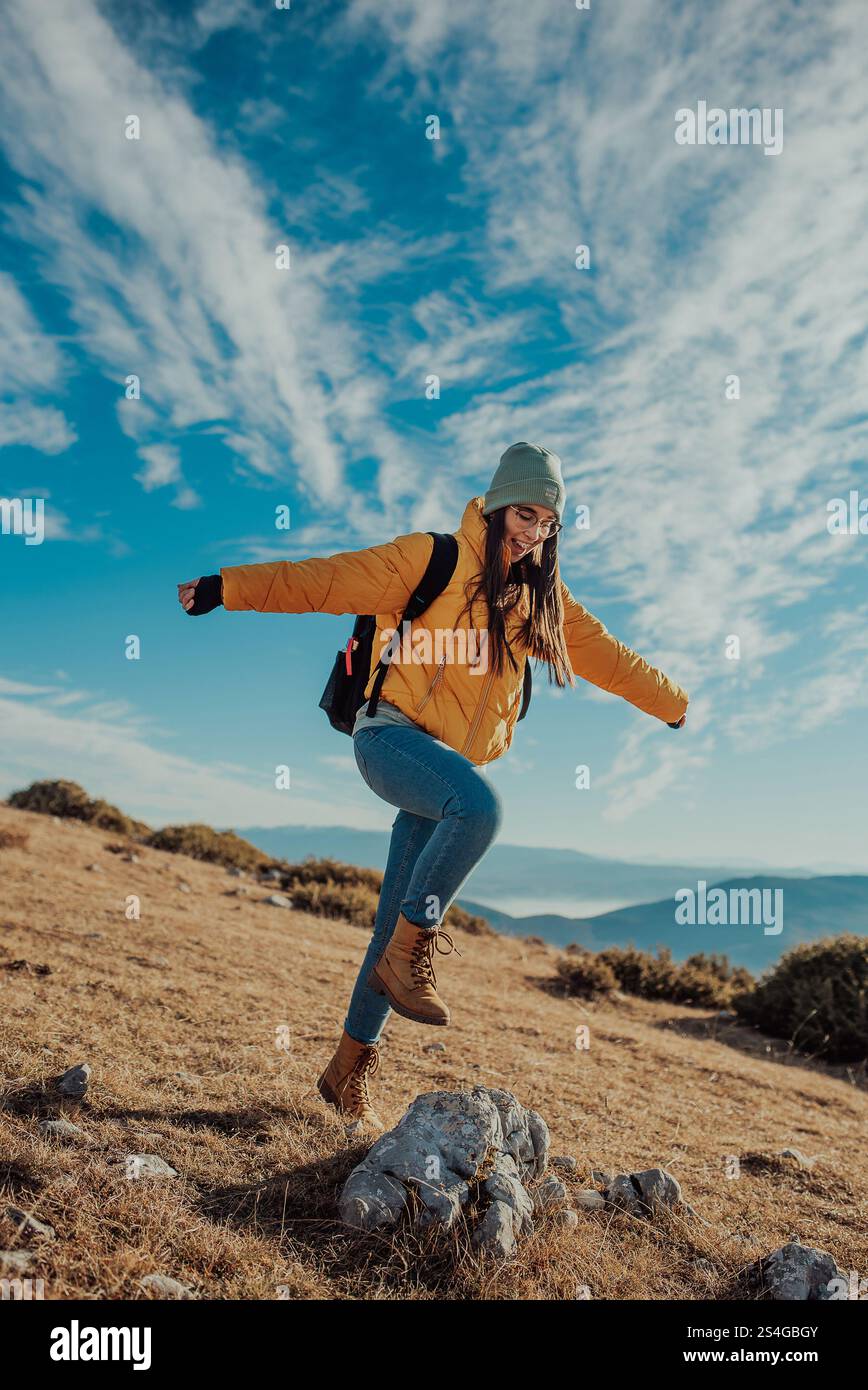 Cheering woman backpacker enjoy the view on sunrise mountain top cliff ...