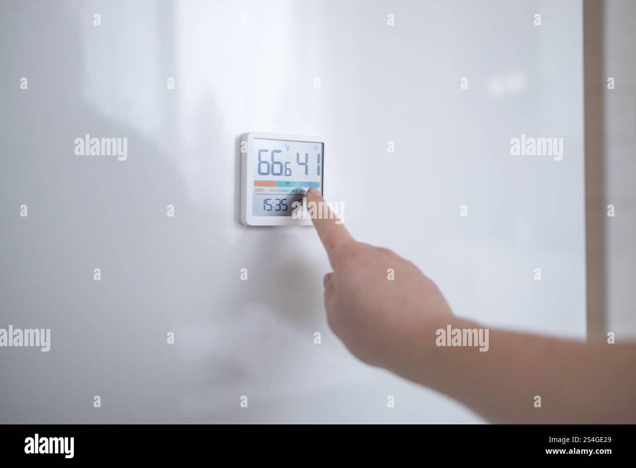 hand adjusting air conditioner button at 70 degree Fahrenheit in the ...