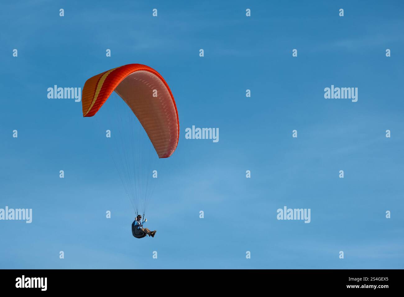Man paragliding high up in the sky. Blue sky with paragliders. Extreme ...
