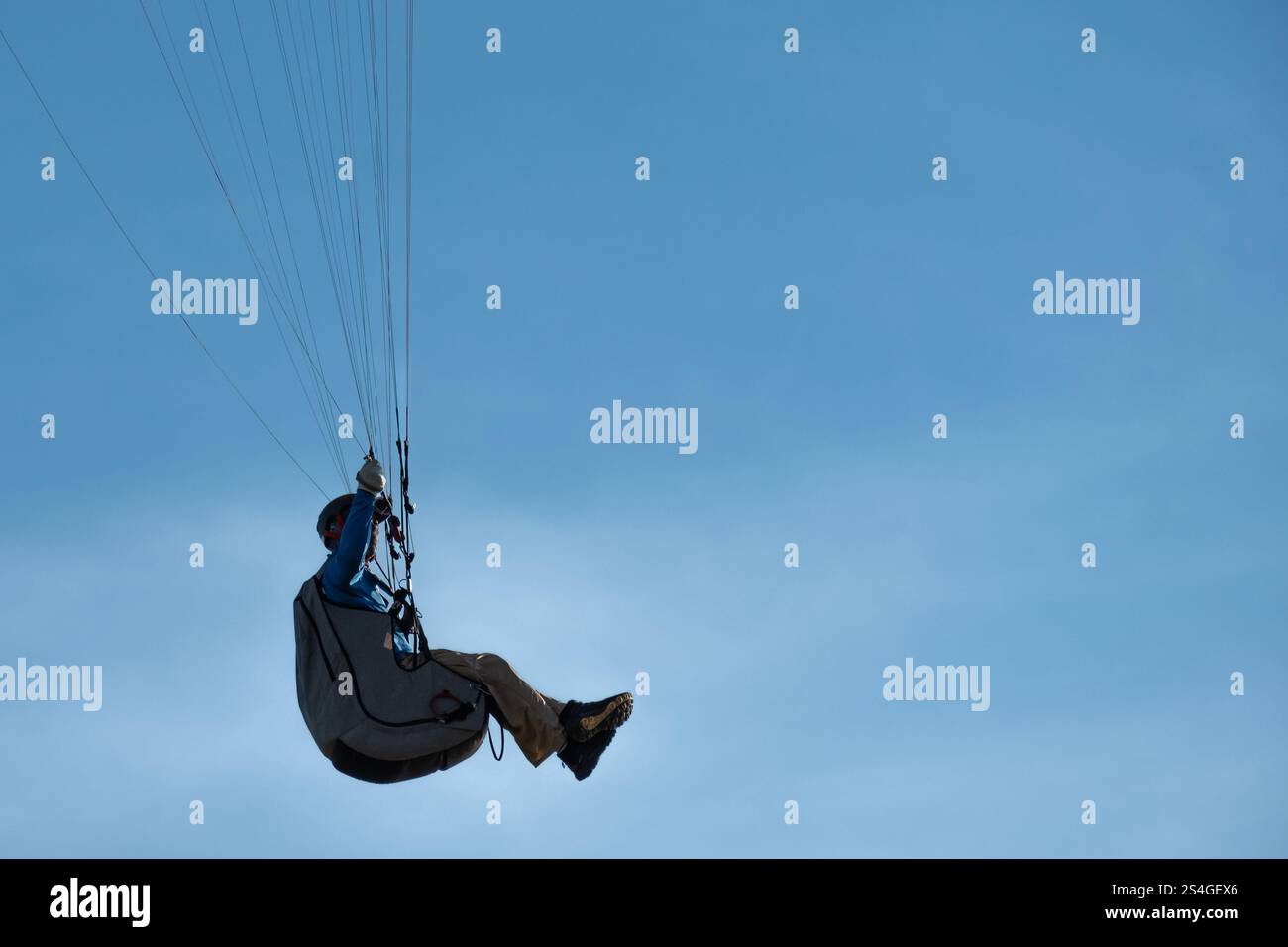 Man paragliding high up in the sky. Blue sky with paragliders. Extreme ...